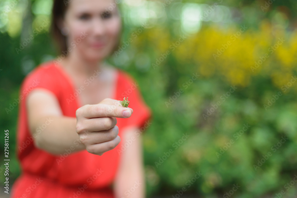 blurred white caucasian young woman in red dress outstretched arm shows ...