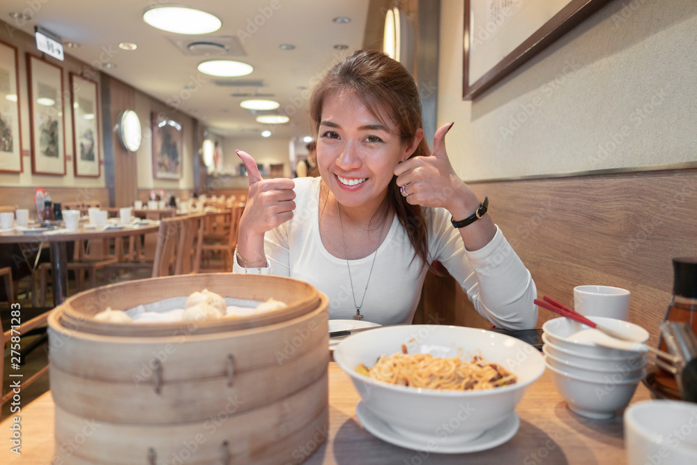 Asian woman show thumbs up sign and eating soup dumplings on restaurant ...