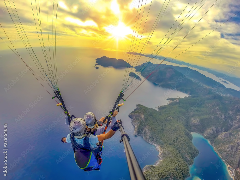Paragliding in the sky. Paraglider tandem flying over the sea with blue ...