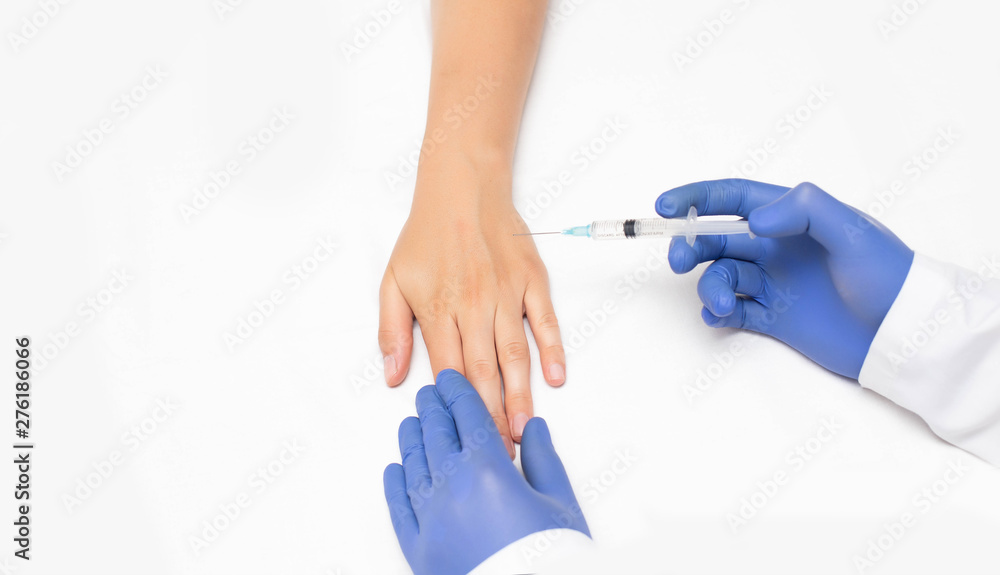 Doctor makes sclerotherapy injection into the arm of the girl's patient ...