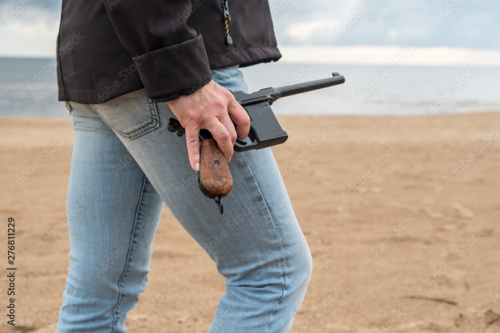Girl in jeans with a gun in hand. Life-size weapons mockup. Summer ...