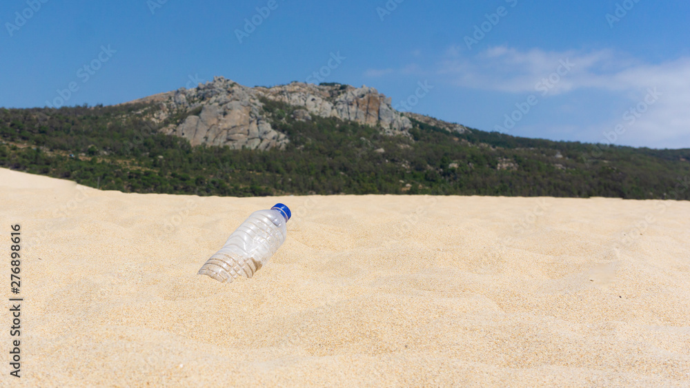 Plastic bottle on the beach sand. Plastic pollution of the oceans ...