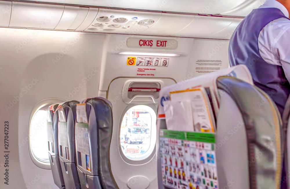 Emergency exit door sign in airplane. Stock Photo | Adobe Stock