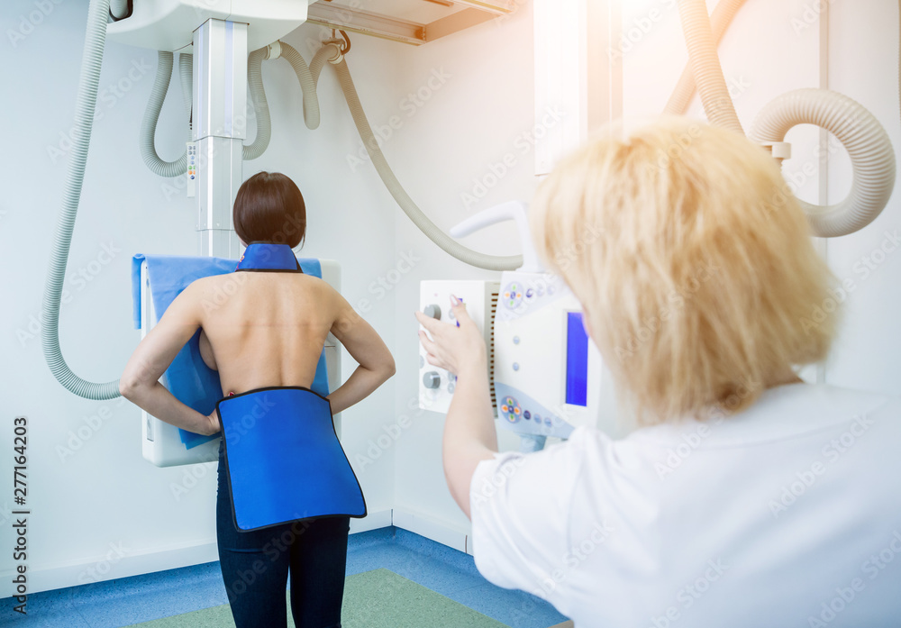 Radiologist and patient in a x-ray room. Classic ceiling-mounted x-ray ...