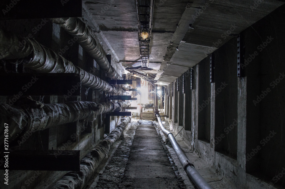 Underground concrete utility tunnel with pipes and wires. Stock Photo ...