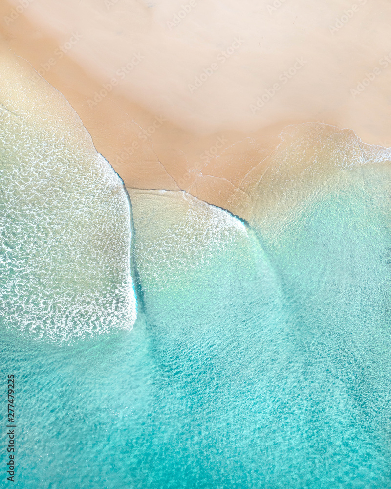 Aerial of a beach with beautiful waves, white sand and ocean textures ...