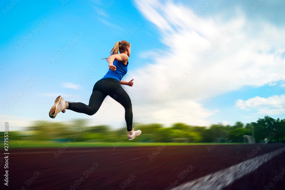 The young girl running in stadium, blur in moving. An athlete runs ...