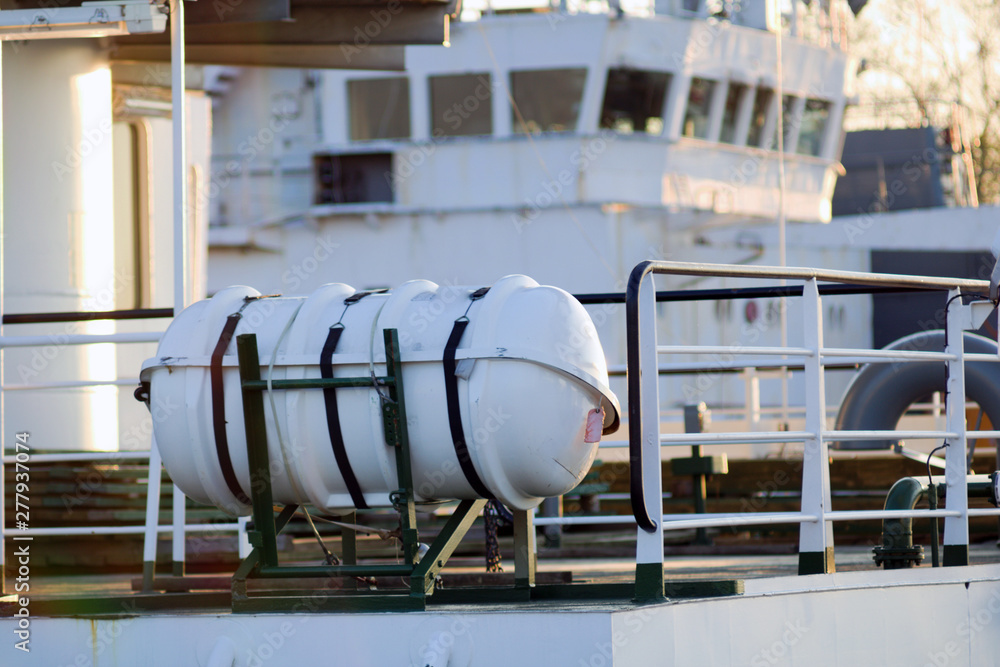 White container with an inflatable liferaft raft aboard ship. Rescue ...