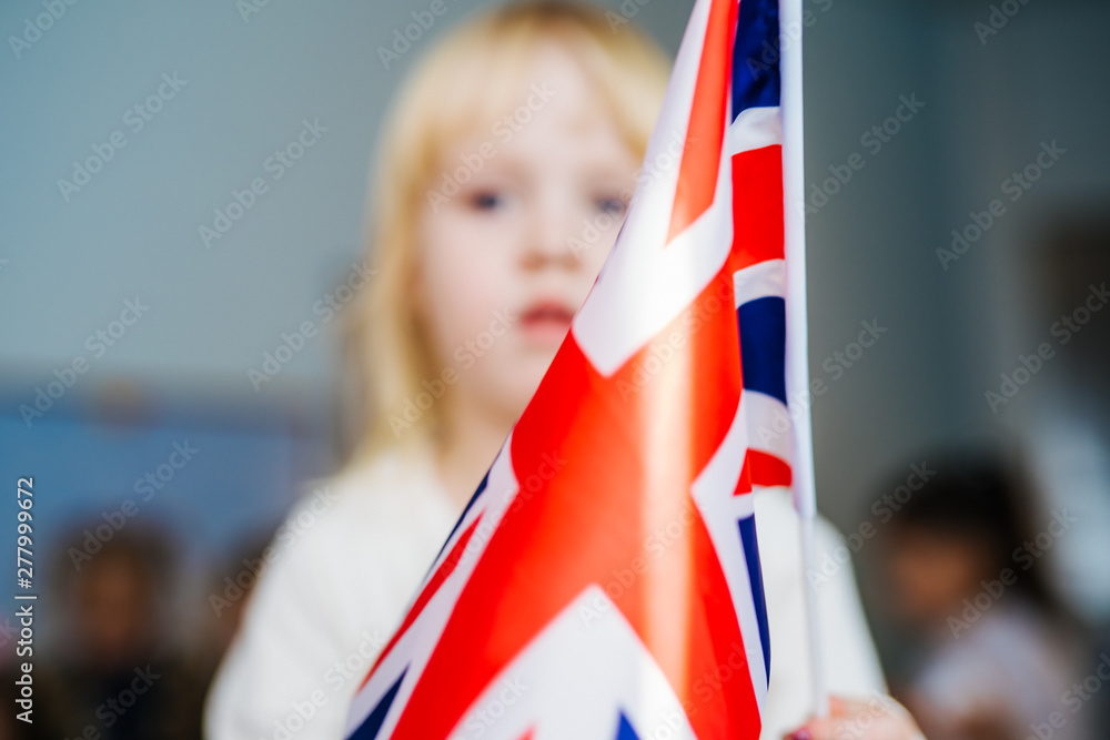 Little girl plays with british flag. Pretty child holds the British ...