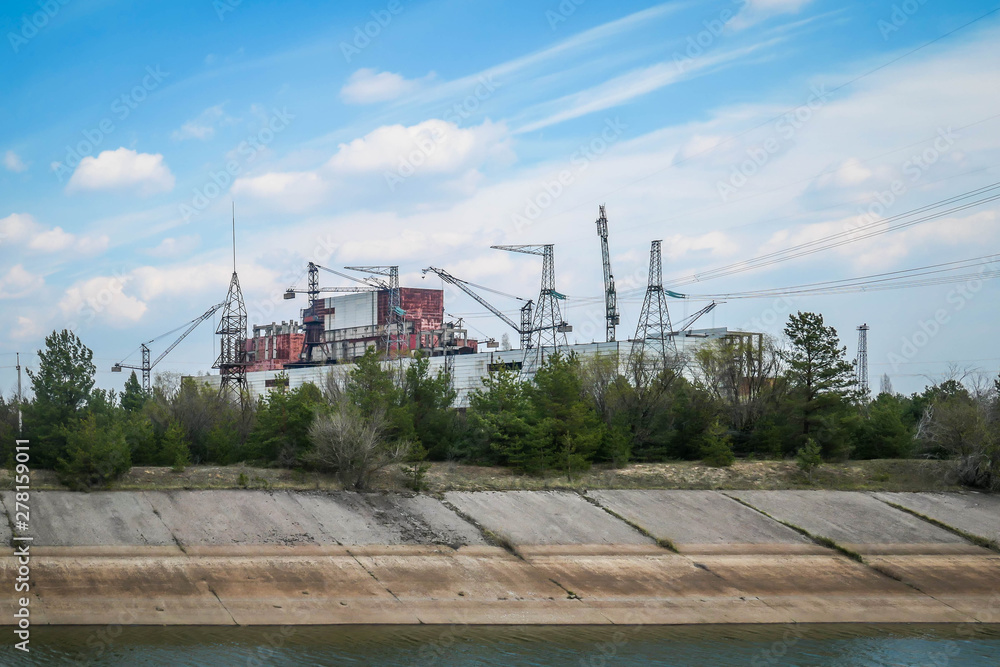 A remote view on the Unit 5 Reactor in Chernobyl, Ukraine. Lush green ...