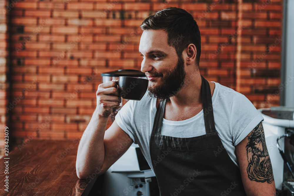 Bearded barista putting one elbow on the bar counter and smiling Stock ...