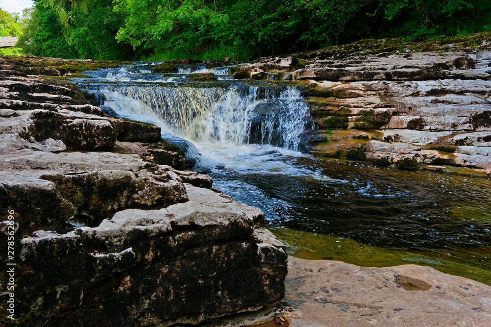 The fast flowing water of the River Ribble becomes blurred as it flows ...