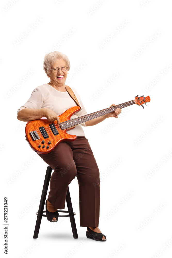 Elderly female guitarist with an electric bass guitar sitting on a ...