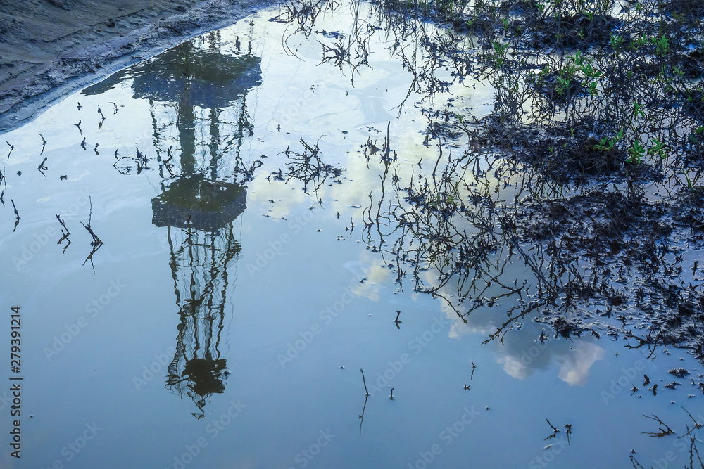Reflection of blurred image of an oil rig in a puddle of oil. Dead ...