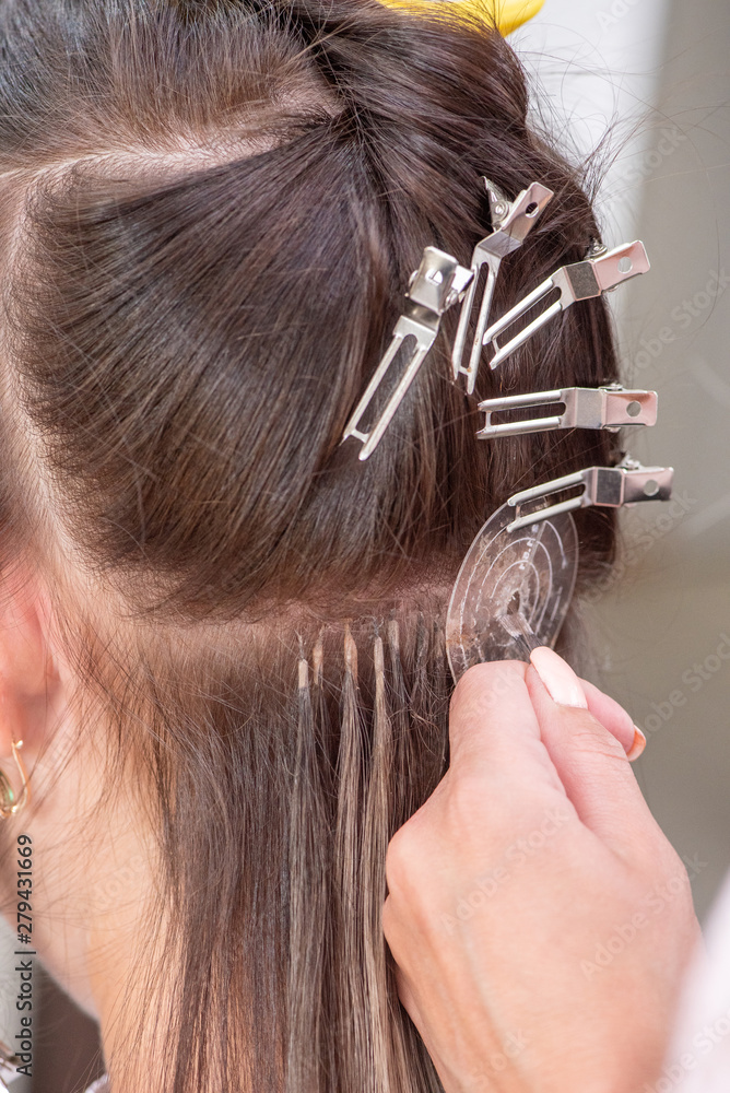 Foto de Stock Professional process of hair extension for a woman with ...