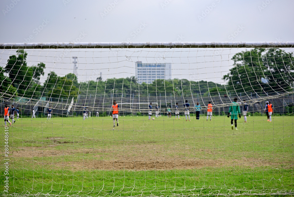 Boys are playing soccer in soccer field, Picture is captured behind ...