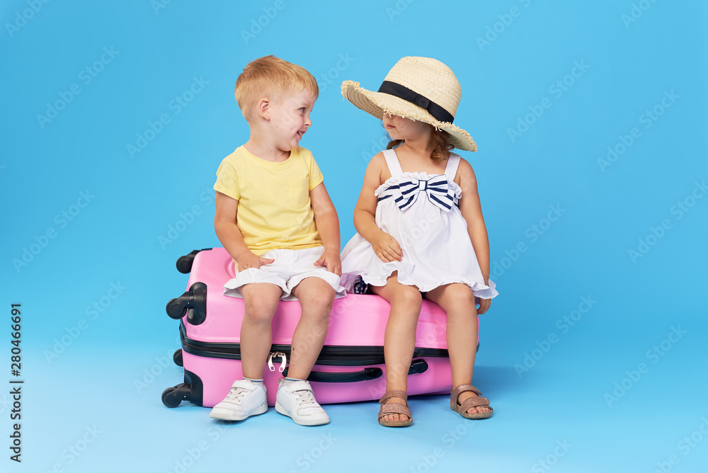 Happy kids sitting on colorful pink suitcase prepared for summer ...