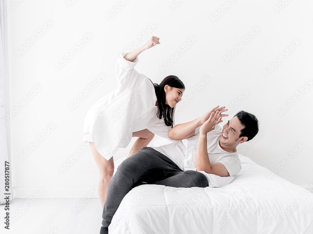 Unfaithful man lying on the bed while the woman is standing over it ...