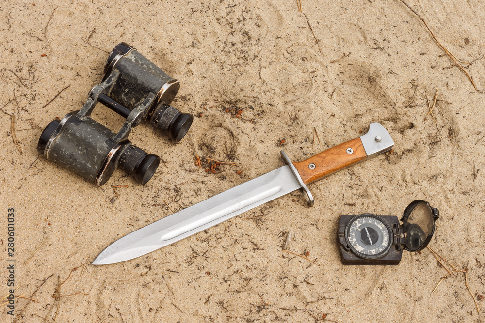 Knife bayonet with wooden handle lies on the sand with old military ...