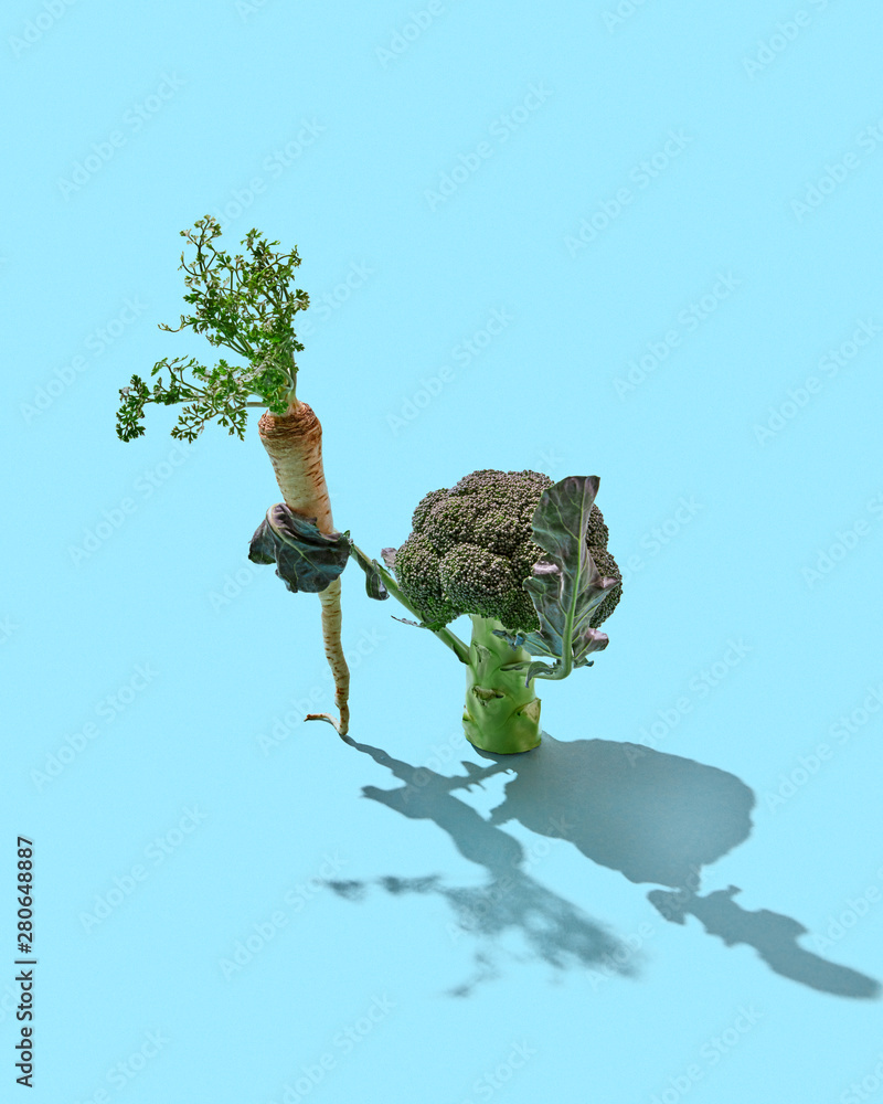 Fresh green broccoli and parsley root with green stems on a blue ...