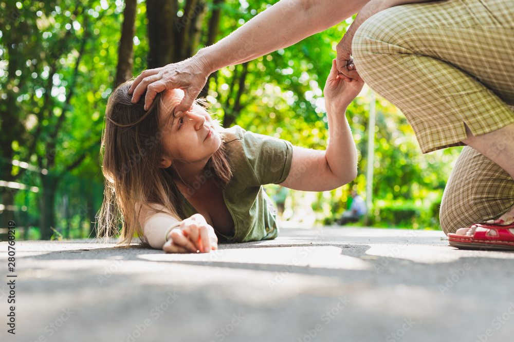 Fainted girl helped by an old woman – Teenager lying on the ground ...