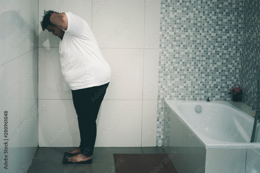 Shocked fat man standing on the scale Stock Photo | Adobe Stock