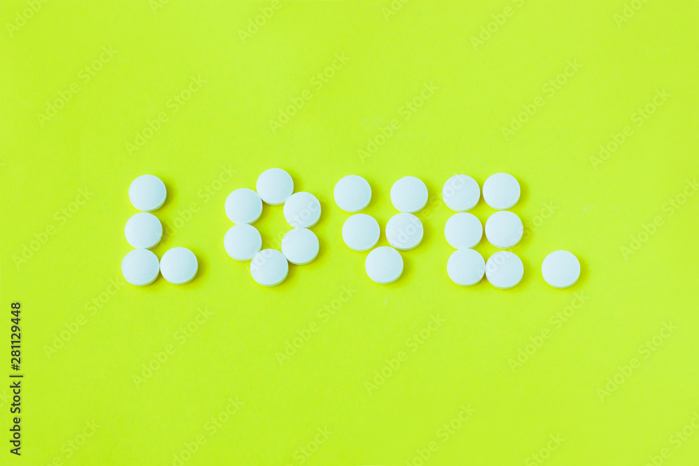 Pills in a shape of a word Love on a yellow background. Flat lay, top ...