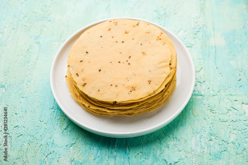 Gujarati papad or papadum in raw dried form with roasted cone, roll and ...