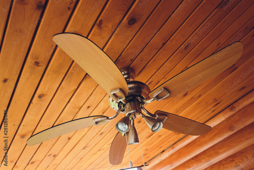 ceiling fan on an exposed support beam, with a vaulted wood ceiling, in ...