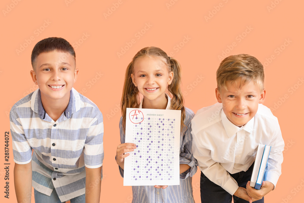Happy children with answer sheet for school test on color background ...