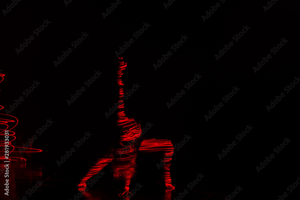 Beautiful dancer moving her body in front of and red light while ...