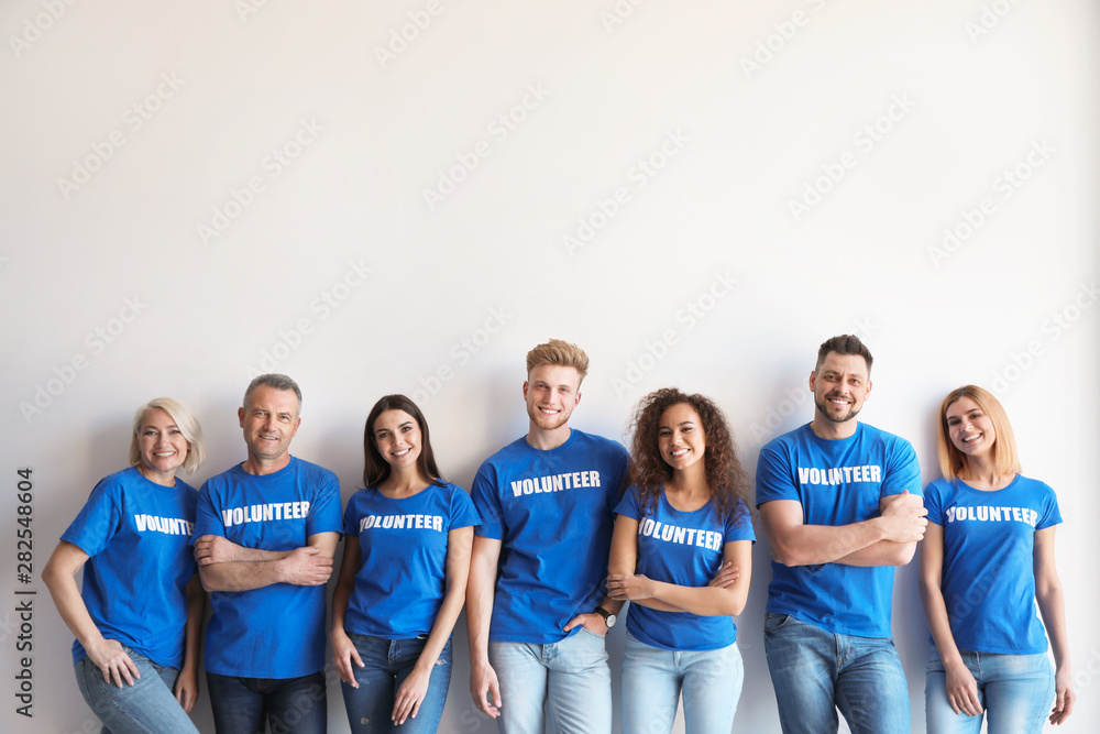 Team of volunteers in uniform on light background Stock Photo | Adobe Stock