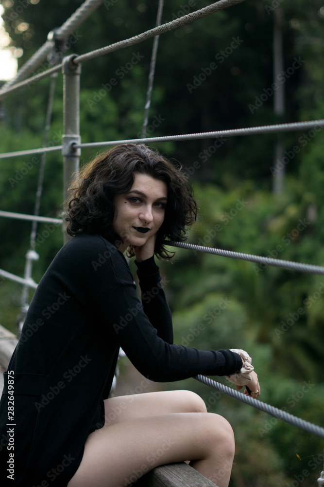 emo goth girl sitting on a bridge looking back at the camera Stock ...