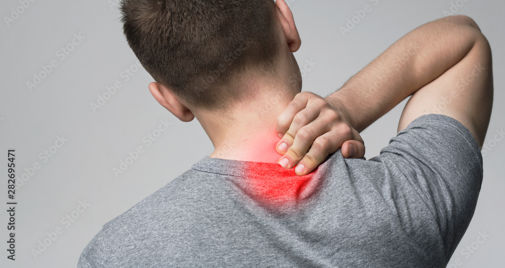 Young man massaging his sore neck, back view Stock Photo | Adobe Stock