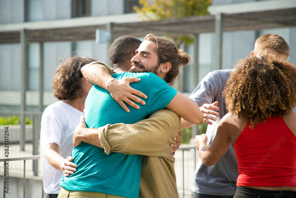 Happy guys in casual hugging each other. Close friends meeting on ...
