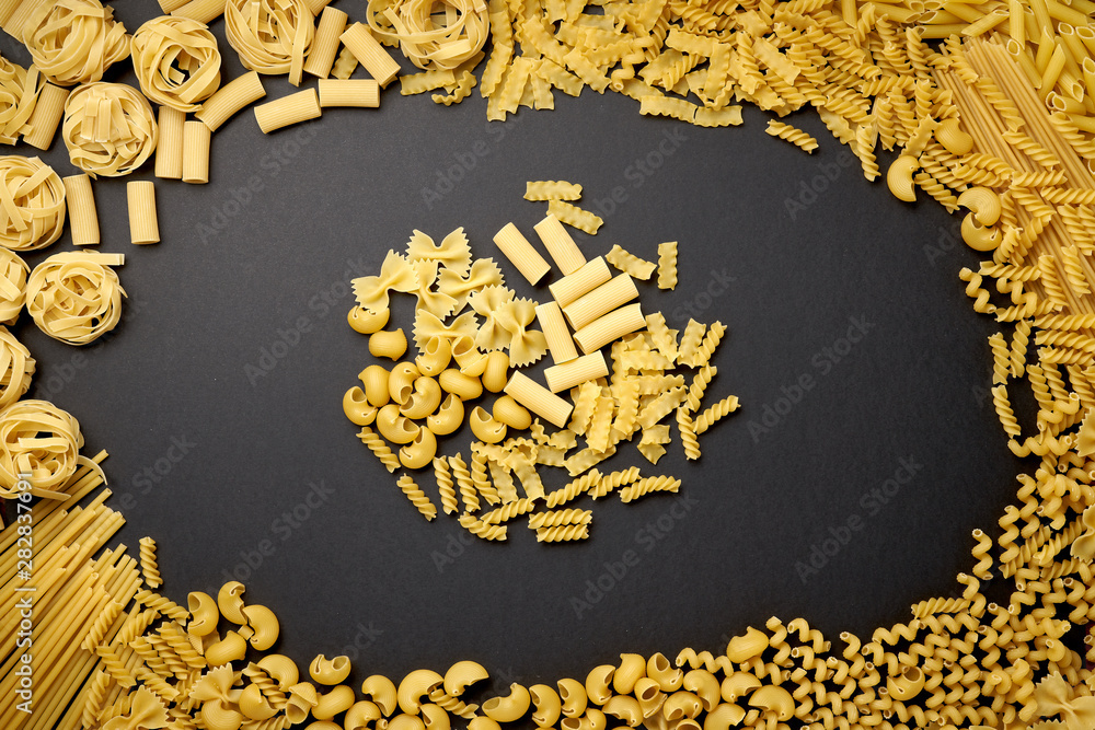 Assorted types of pasta on black background. Top view. Various forms of ...