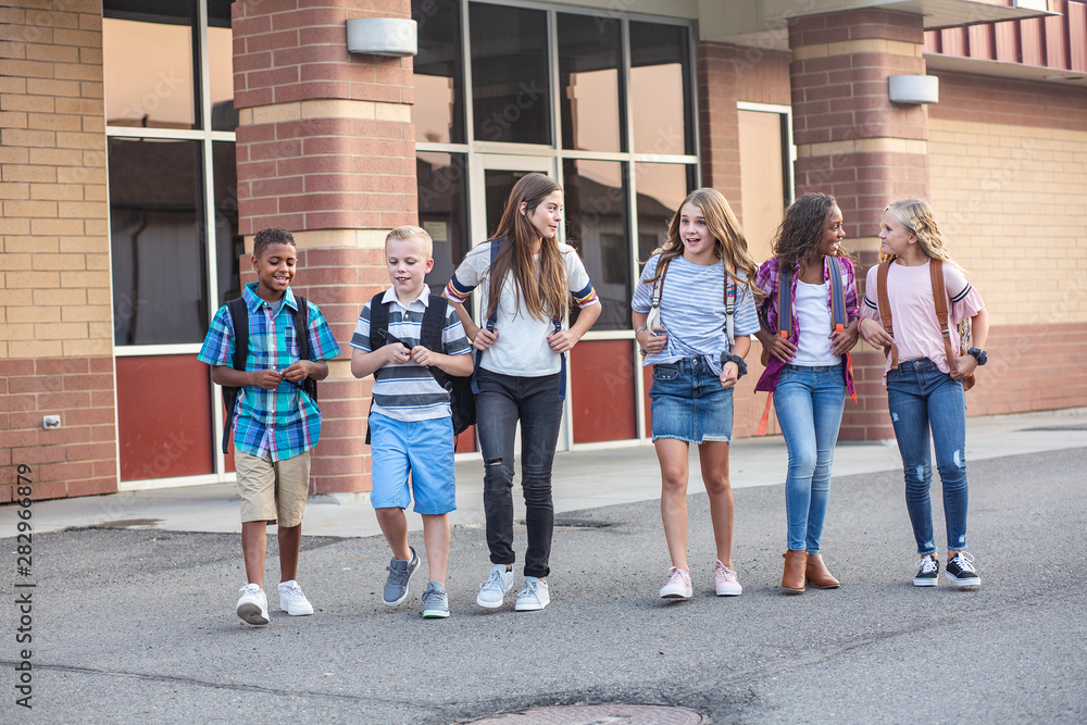 Large, diverse group of kids leaving school at the end of the day ...