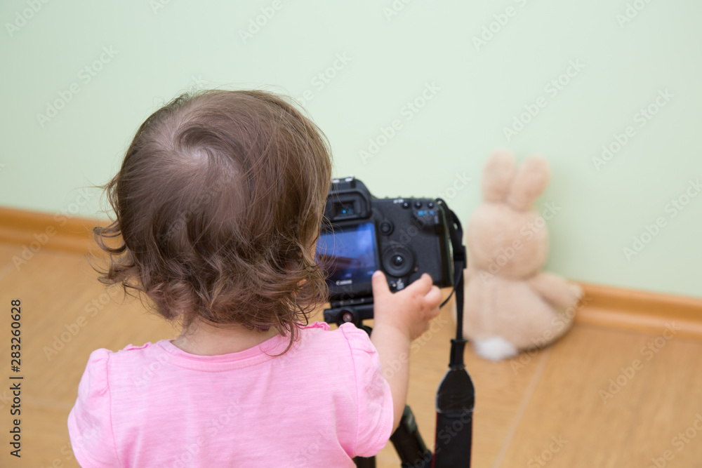 Cute funny beautiful baby photographs her bunny. The baby stands and ...