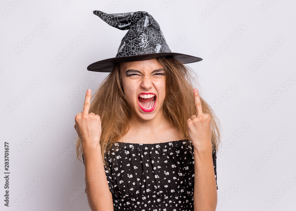 Happy halloween concept. Angry Teen girl in witch black hat showing ...