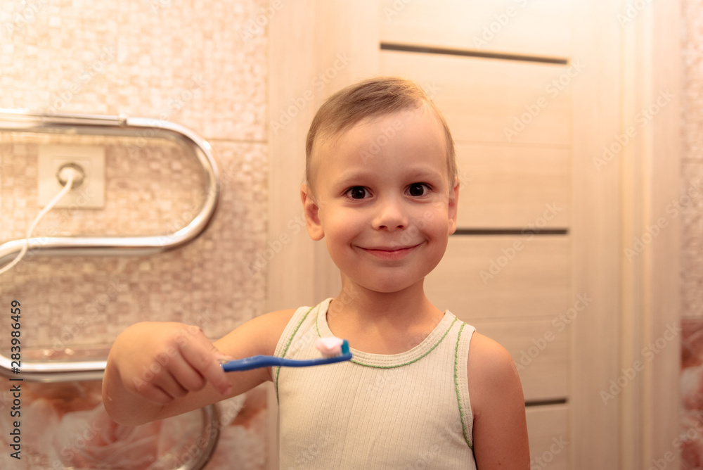 Little kid boy brushing his teeth in the bathroom. Smiling child ...