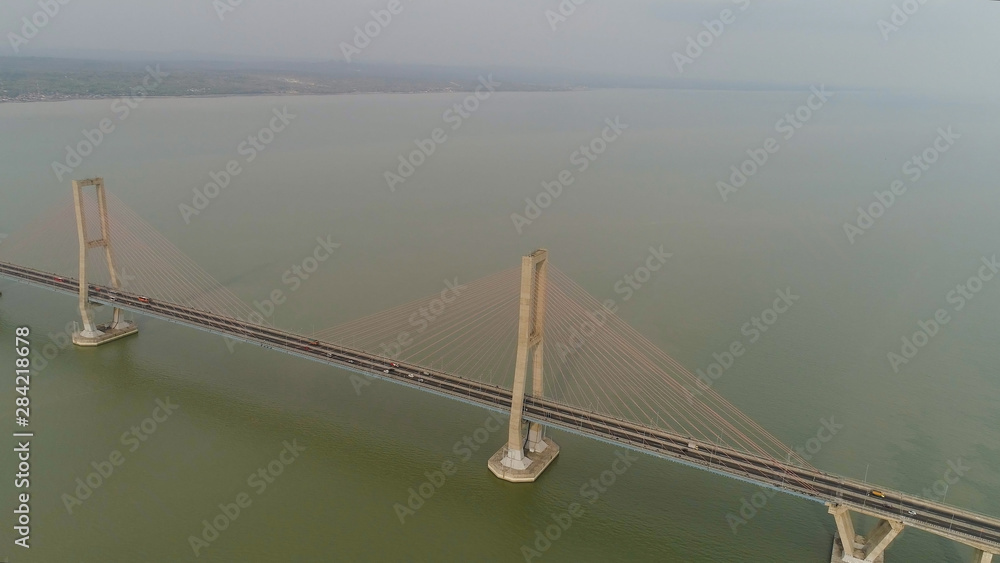 suspension bridge over madura strait with highway and car, surabaya ...