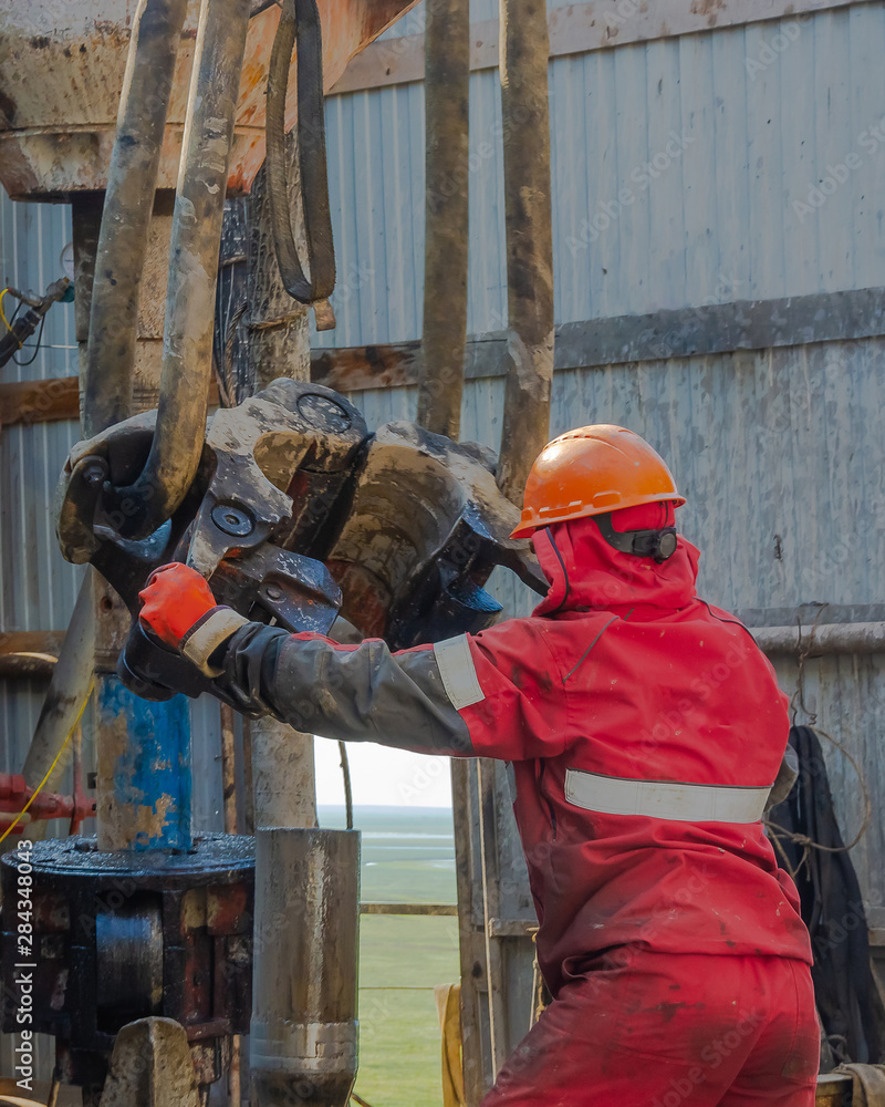 Foto de Stock Work driller in red uniform, in helmet and goggles. He ...