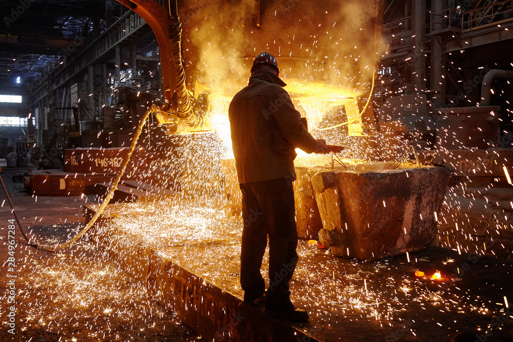 Steelmaker at ingot casting. Electric arc furnace shop EAF. Metallurgy ...
