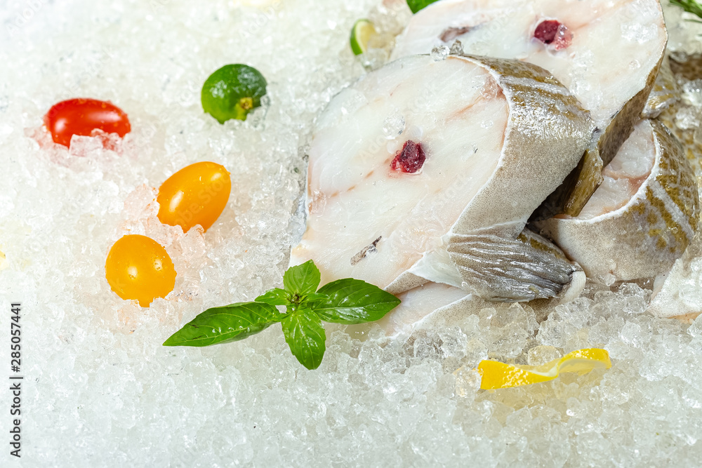 fresh sea ocean white fish sliced in pieces, lying on ice, headless ...