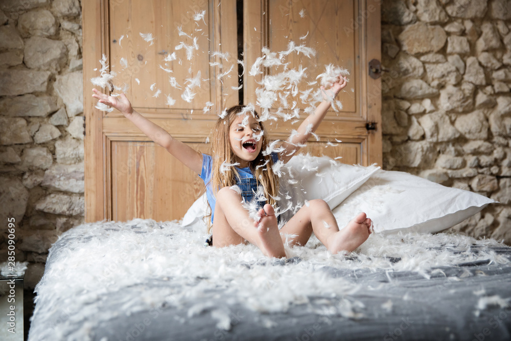 Happy little girl playing with stuffing from a feather pillow Stock ...