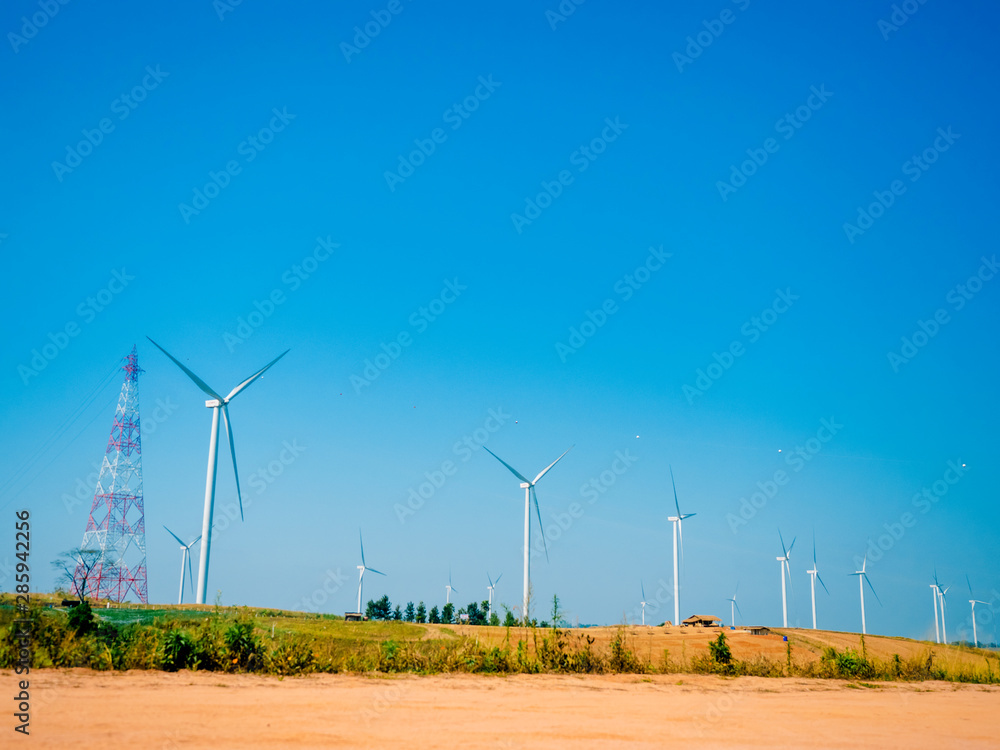 earth day and renewable energy concept with white wind turbine in large field with beauty sky in ...