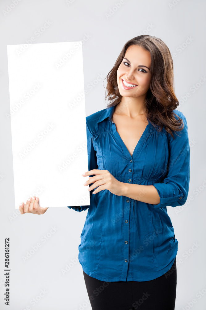 Happy smiling beautiful young businesswoman showing blank sign board ...