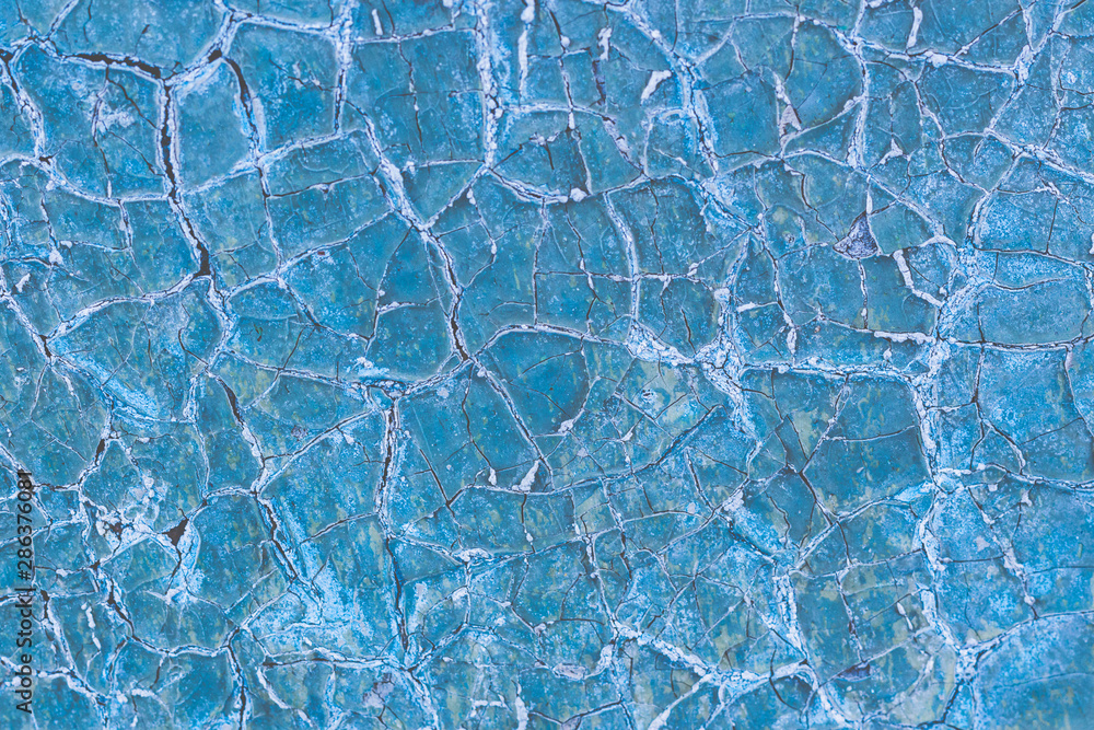 Texture of a dry cracked blue paint on a metal surface. Cracks on the ...