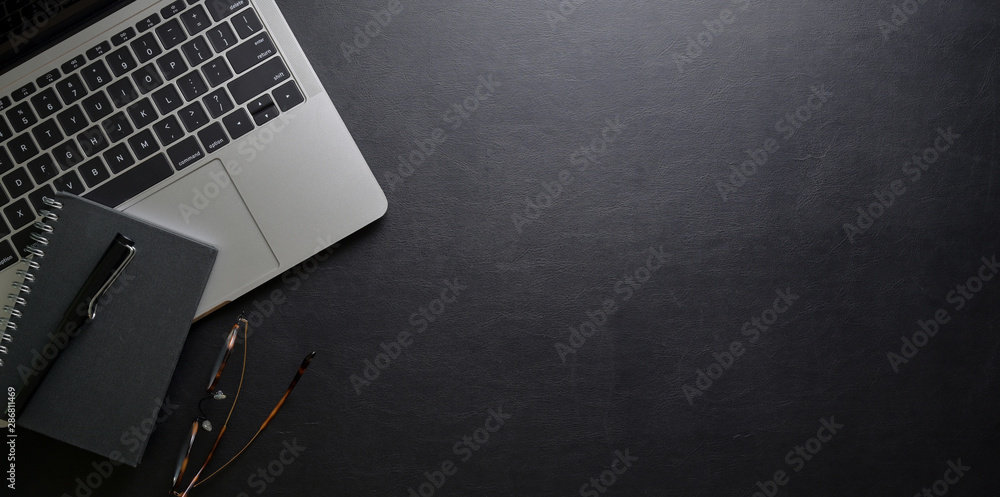 Top view of dark trendy workplace with laptop computer and office ...
