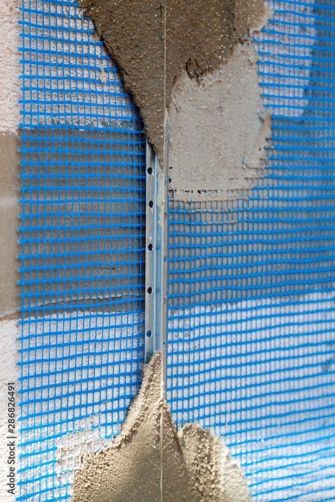 surface of wall with applied construction grid and guides for plaster ...